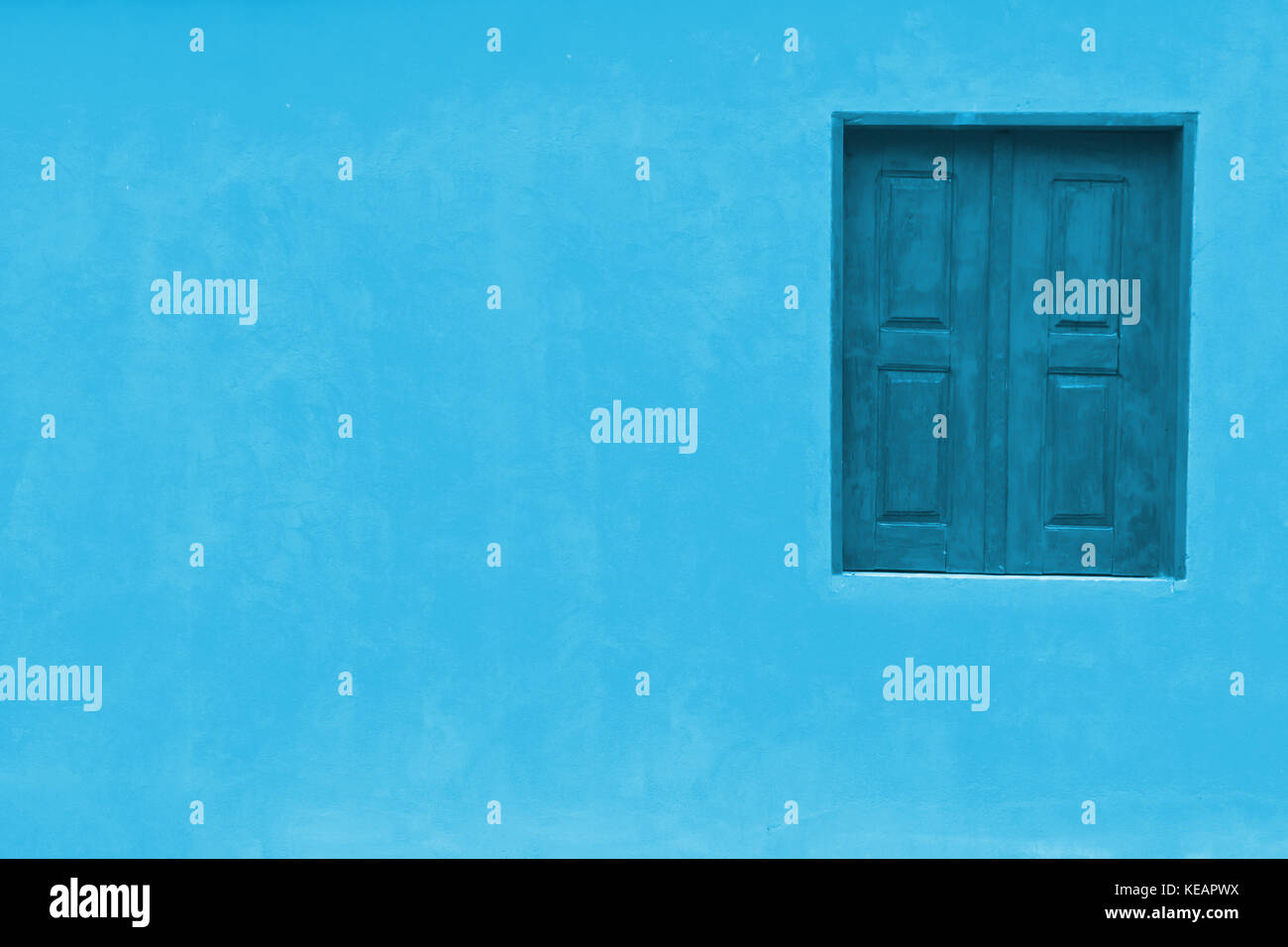 Light baby blue color facade with darker blue window and large empty ...