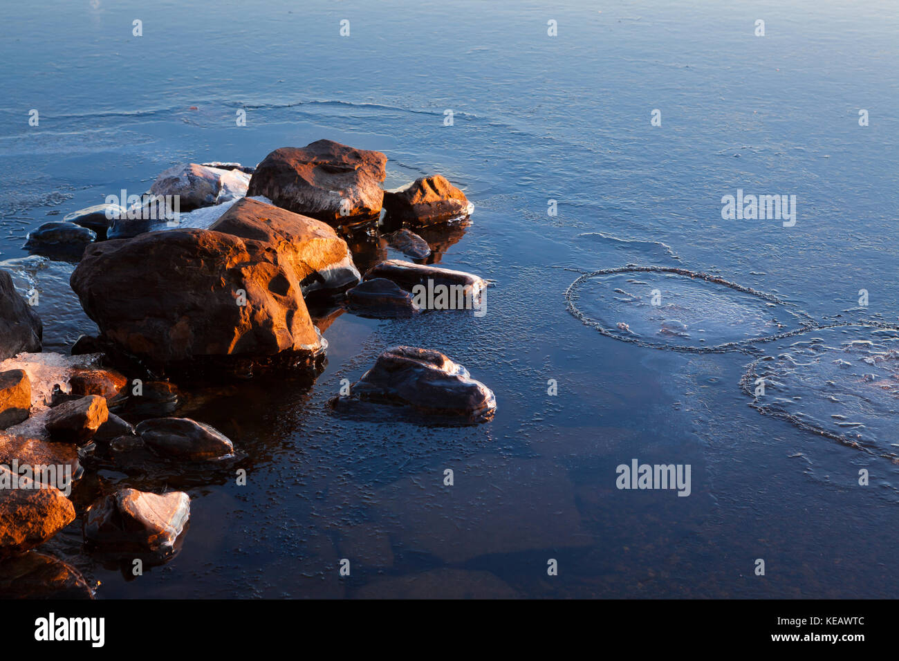 Frozen lake and rocks Stock Photo - Alamy