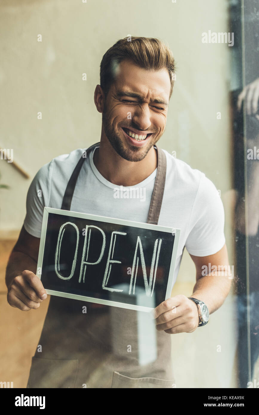waiter holding chalkboard with open word Stock Photo - Alamy