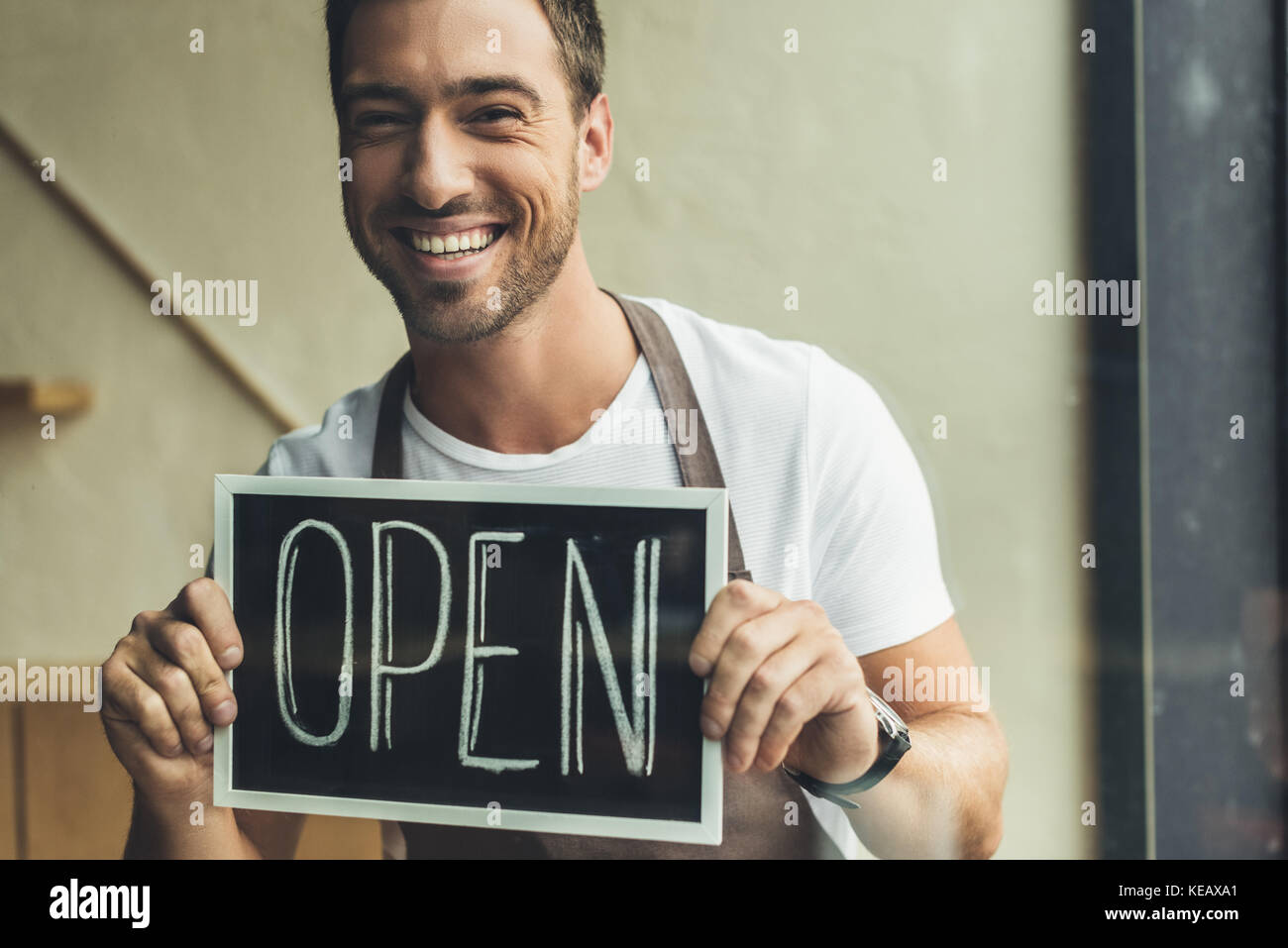 waiter holding chalkboard with open word Stock Photo - Alamy