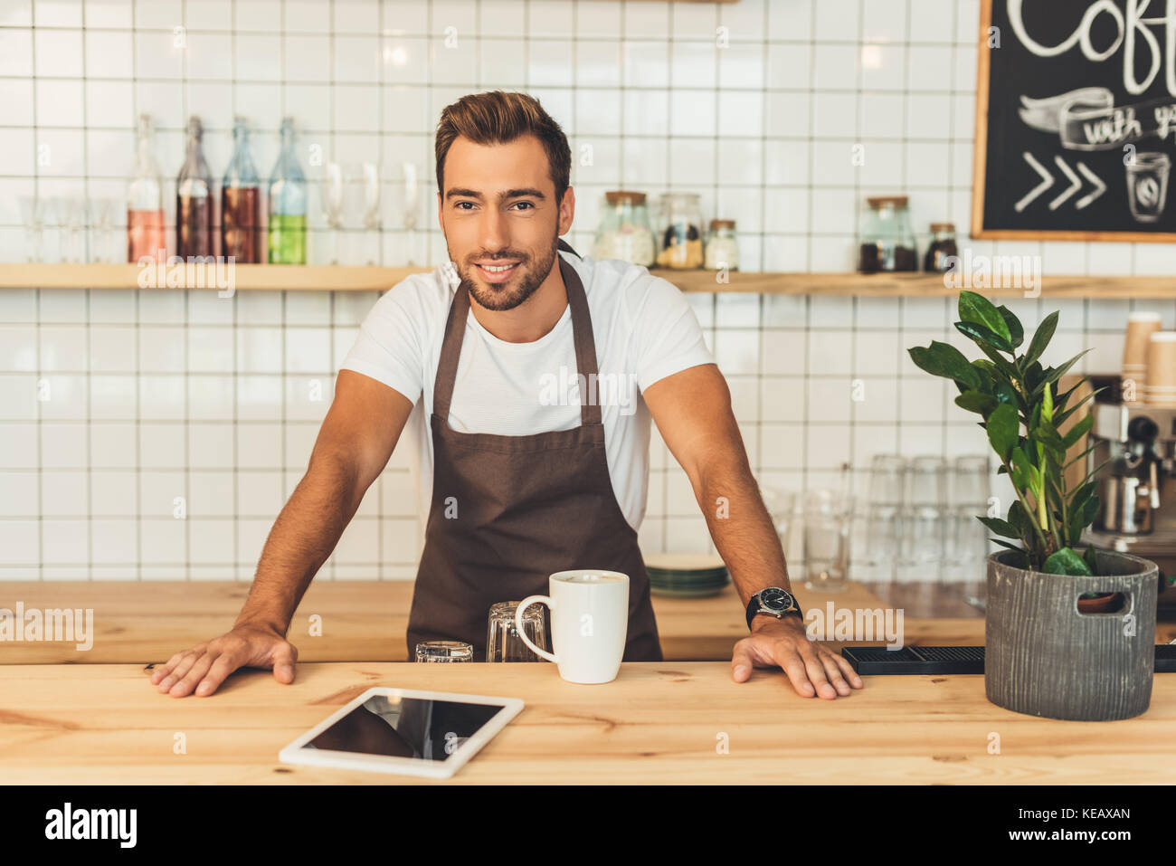 smiling barista at counter with tablet Stock Photo - Alamy