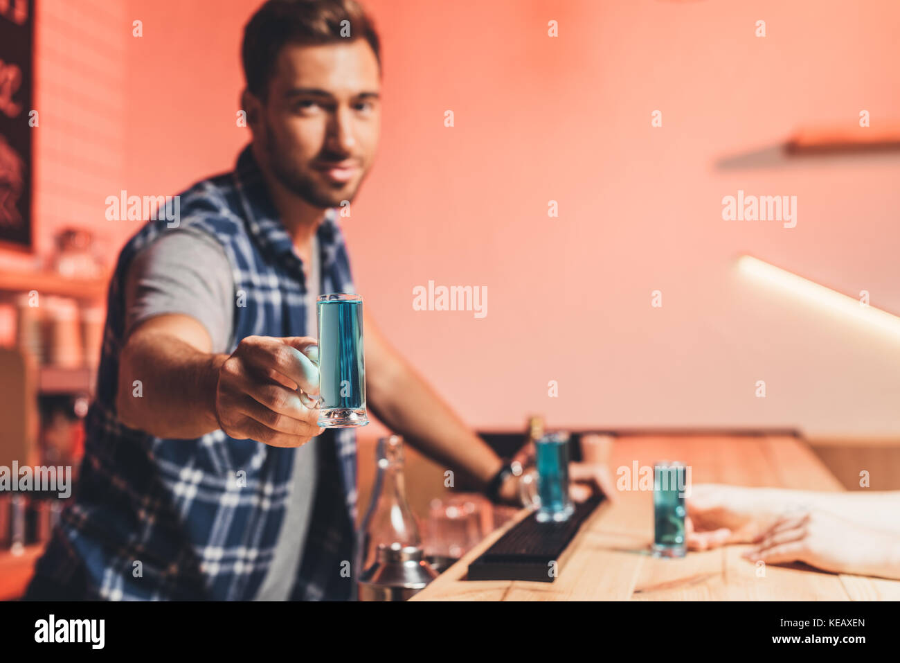 barman holding alcohol shot Stock Photo - Alamy