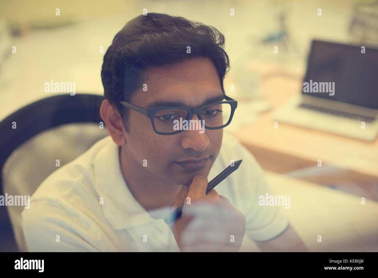 indian business male working shot through glass window Stock Photo - Alamy