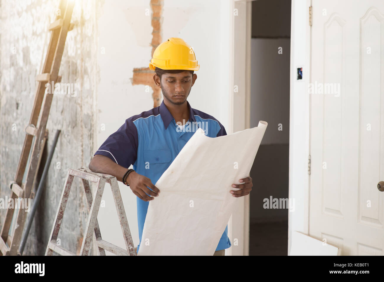 indian male construction worker reading plans Stock Photo - Alamy