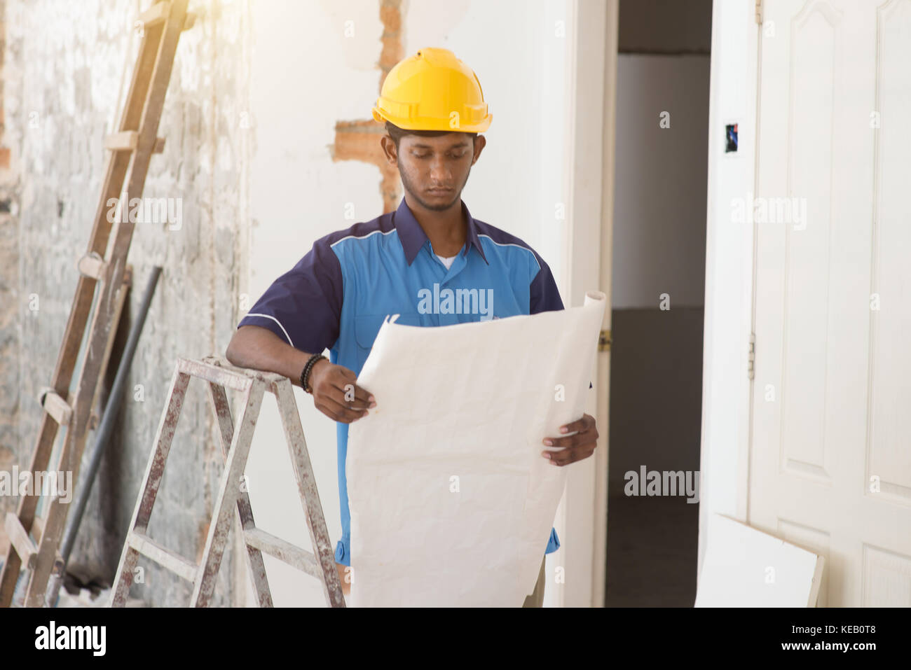 indian male construction worker reading plans Stock Photo - Alamy