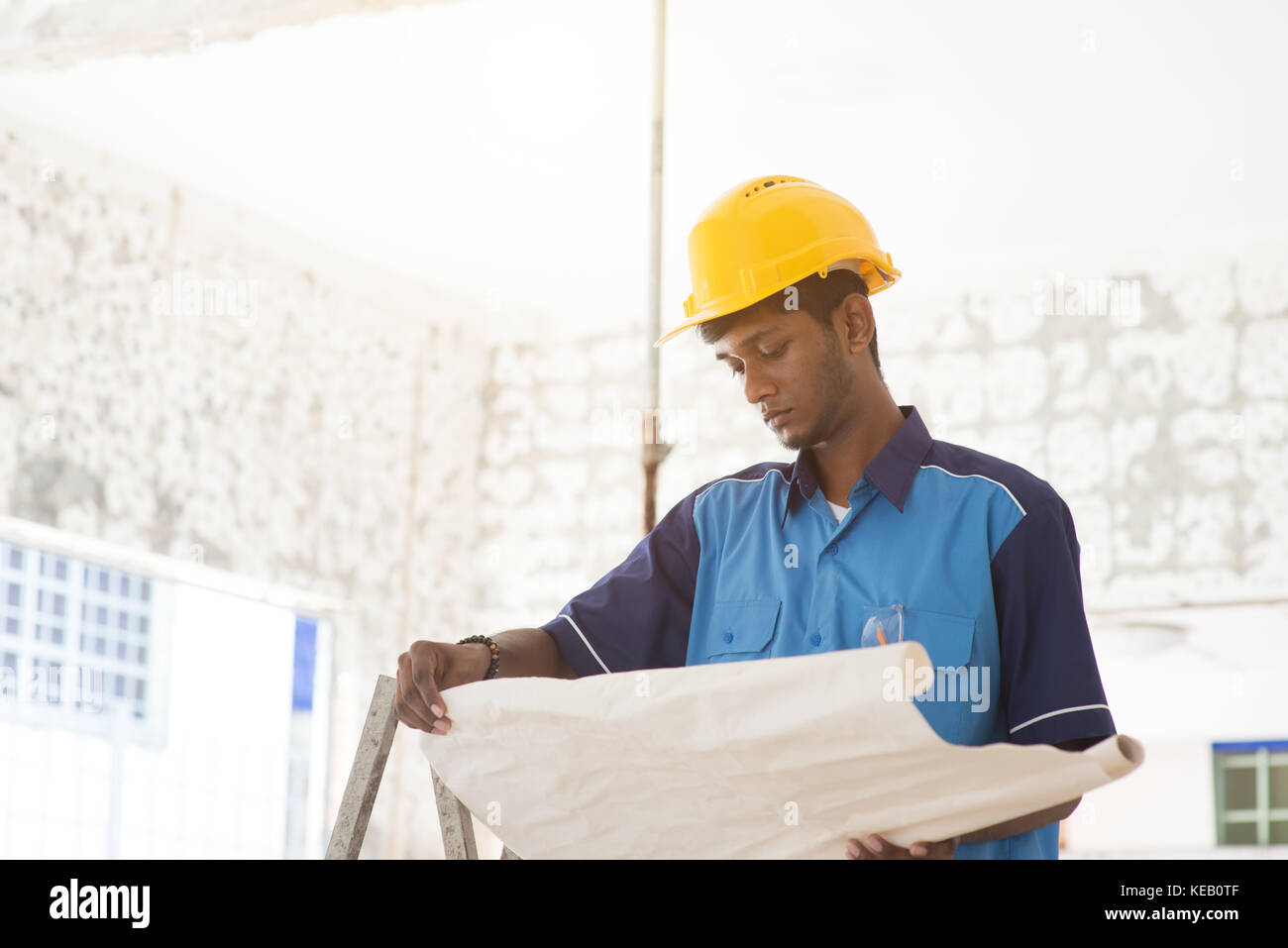 indian male construction worker reading plans Stock Photo - Alamy