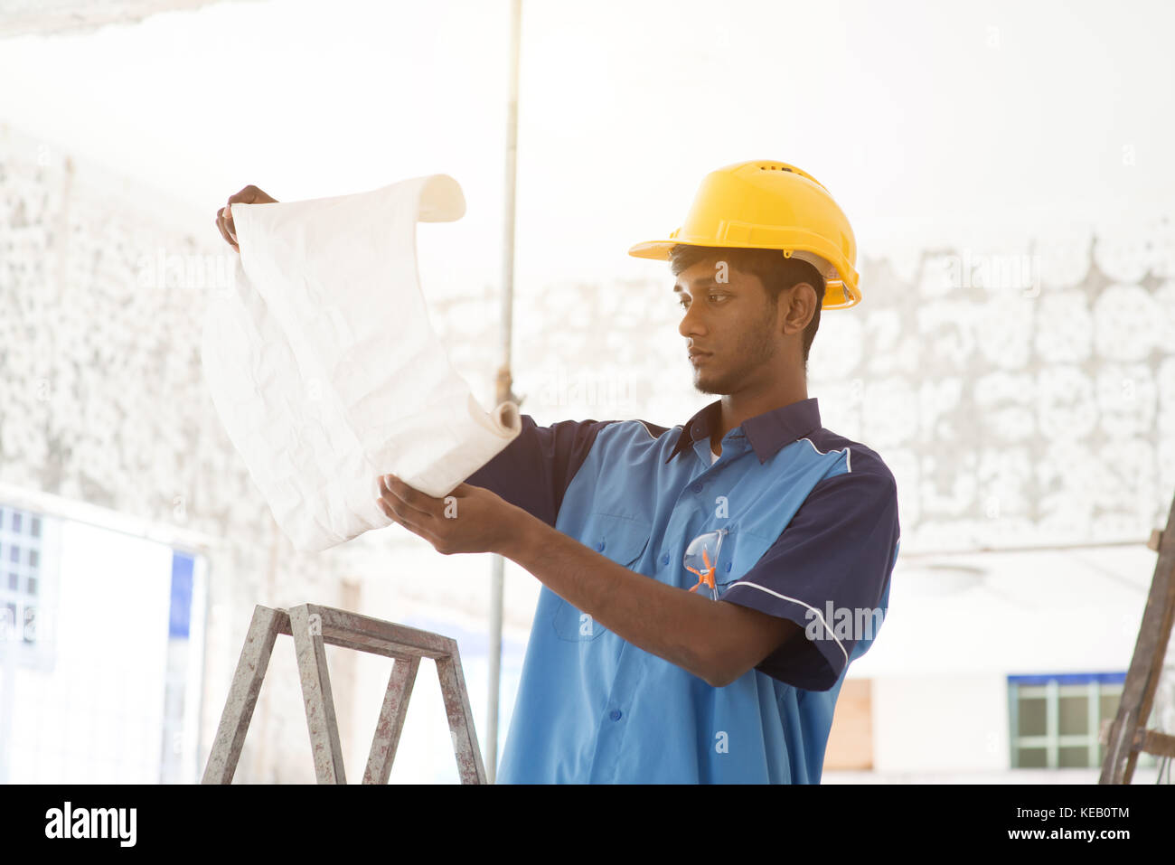 indian male construction worker reading plans Stock Photo - Alamy