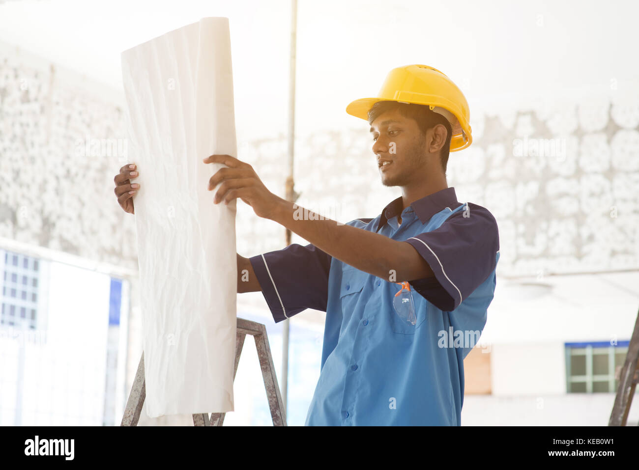 indian male construction worker reading plans Stock Photo - Alamy