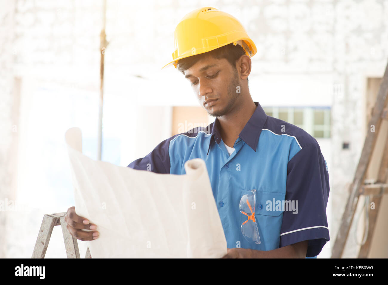 indian male construction worker reading plans Stock Photo - Alamy