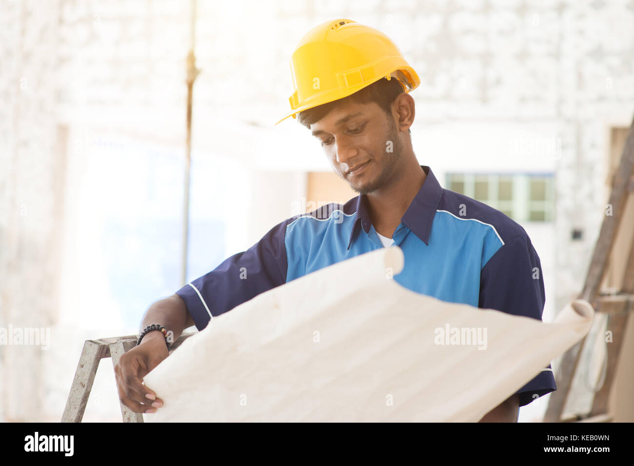 indian male construction worker reading plans Stock Photo - Alamy
