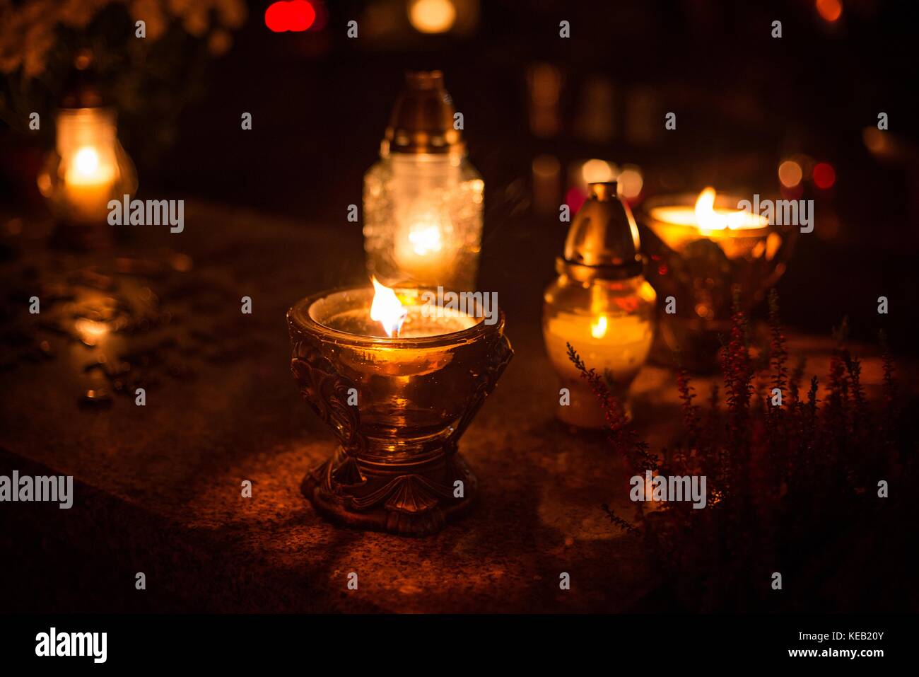 Burning colourful candles on cemetery at night. 1st november All Saints ...