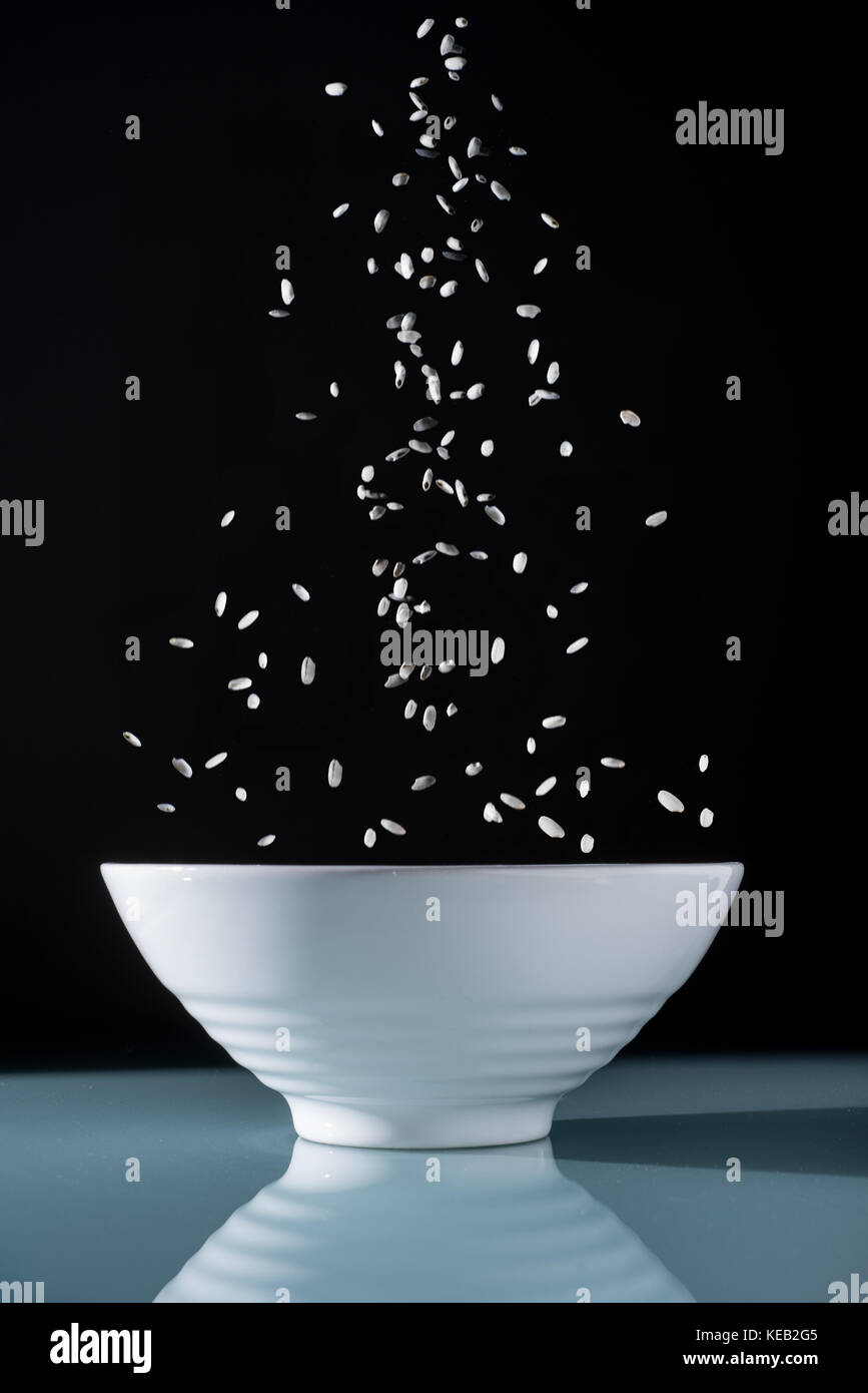 rice falling in a white oriental bowl Stock Photo - Alamy