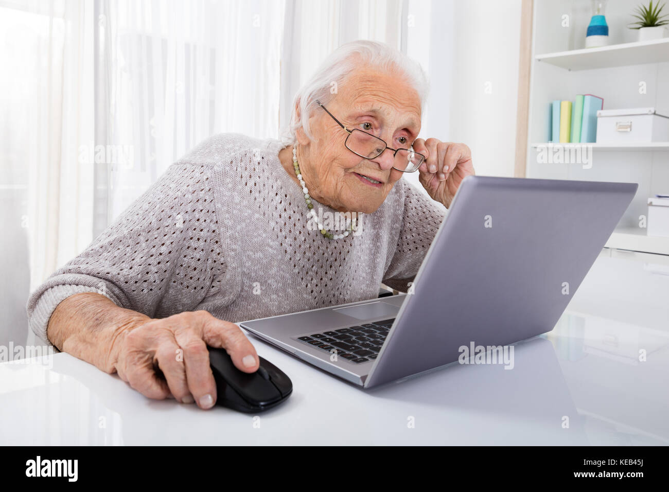 Old woman browsing internet using hi-res stock photography and images ...