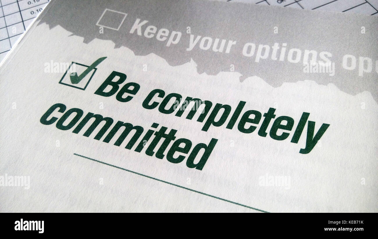 Be completely committed printed on a book Stock Photo - Alamy
