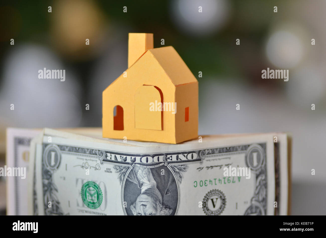 Paper made house stands on dollar money Stock Photo - Alamy