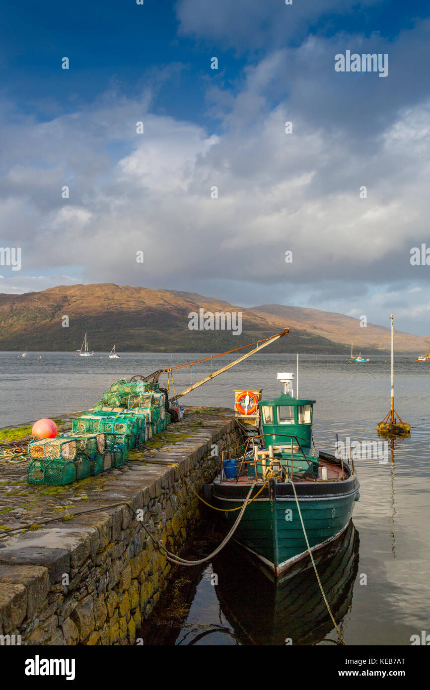 A fishing boat and lobster pots at the small stone pier at Isleornsay ...