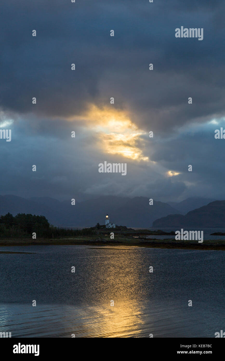 Dramatic dawn light and sunbeams at Ornsay lighthouse on the islet of ...