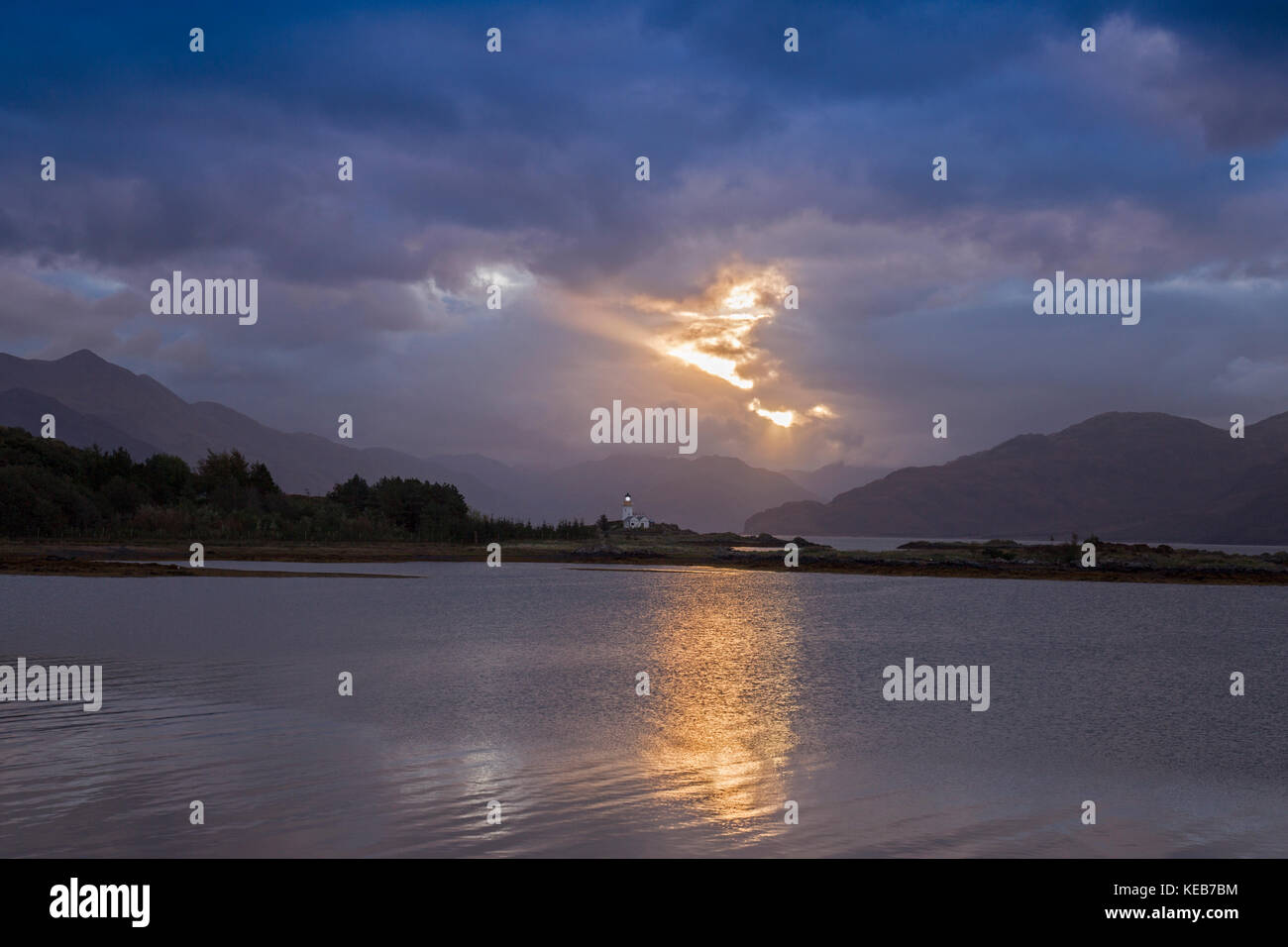 Dramatic dawn light and sunbeams at Ornsay lighthouse on the islet of ...