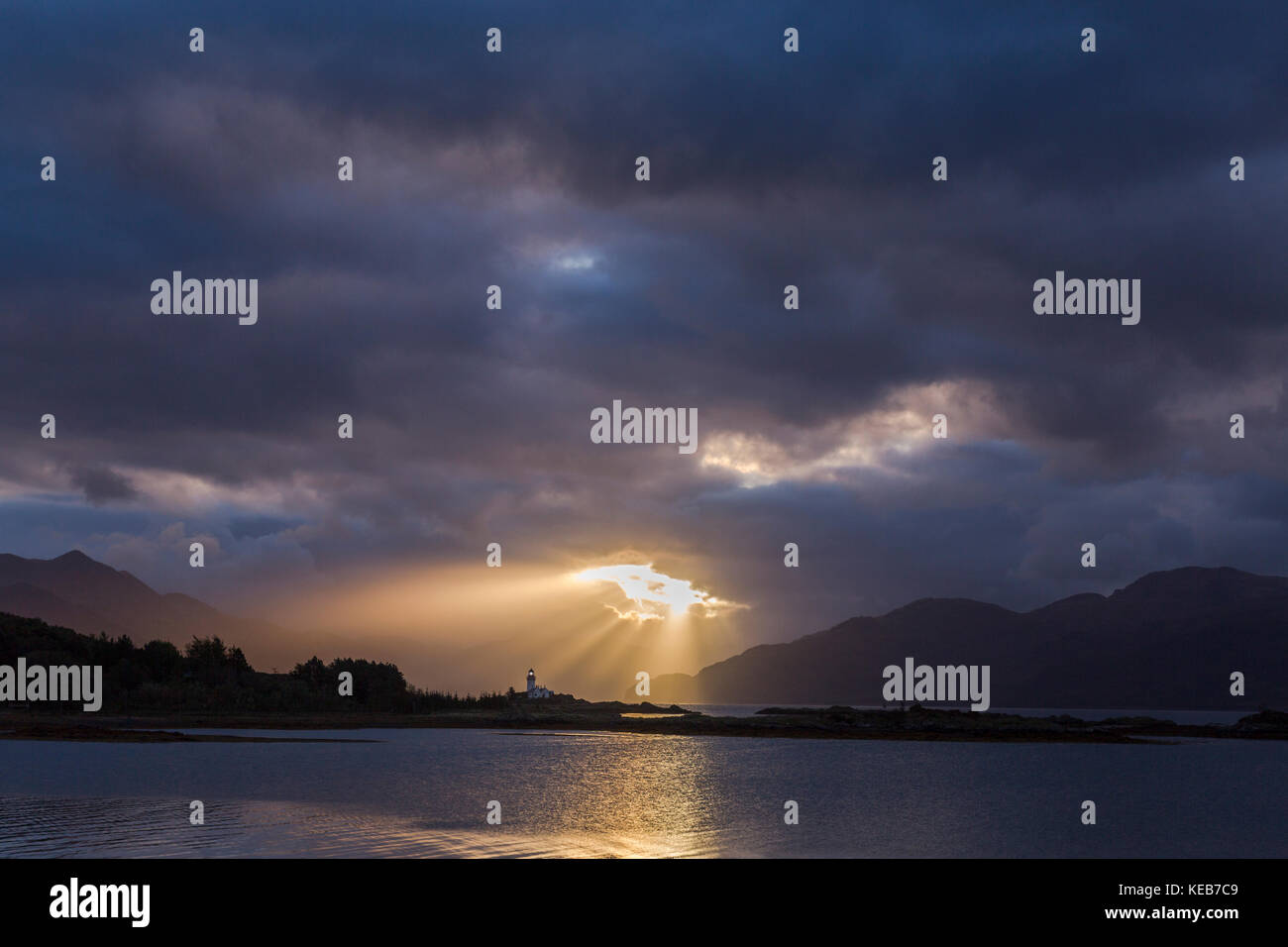 Dramatic dawn light and sunbeams at Ornsay lighthouse on the islet of ...