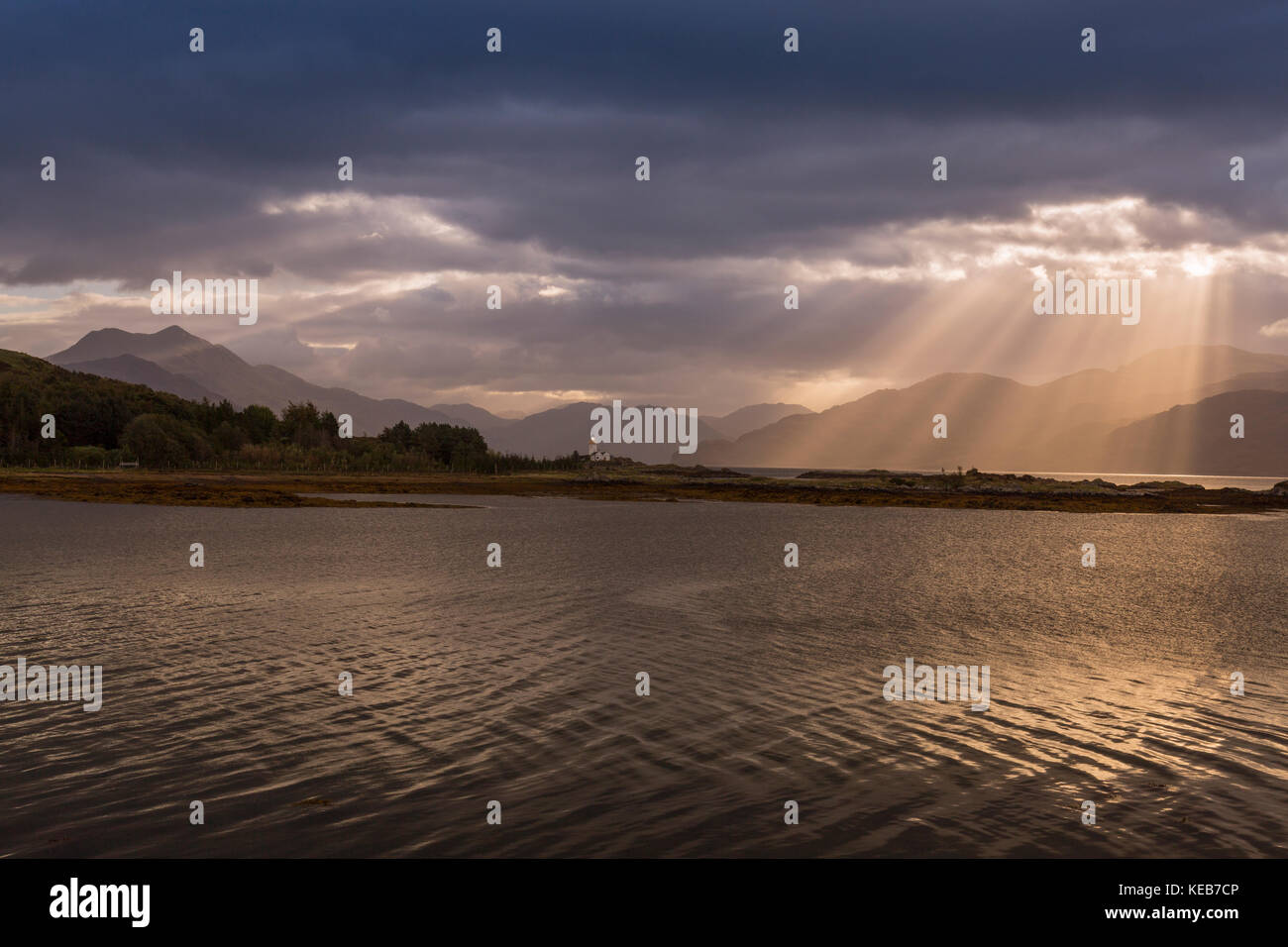 Dramatic dawn light and sunbeams at Ornsay lighthouse on the islet of ...