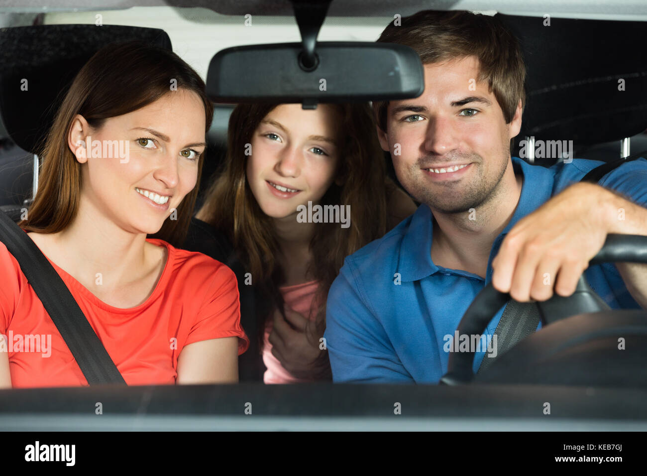 Happy Young Couple Driving In Car With Their Daughter Stock Photo - Alamy