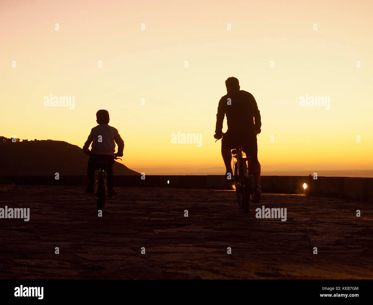 Father and son ridding bicycle in the sunset Stock Photo - Alamy
