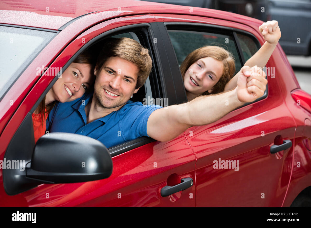 Happy Family Sitting In Newly Purchased Car Raising Their Arms Stock ...