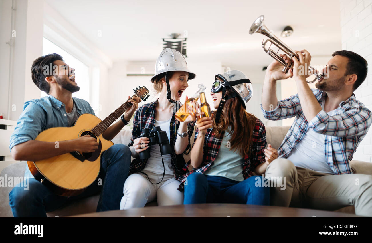 Cheerful friends having party together and playing instruments Stock ...