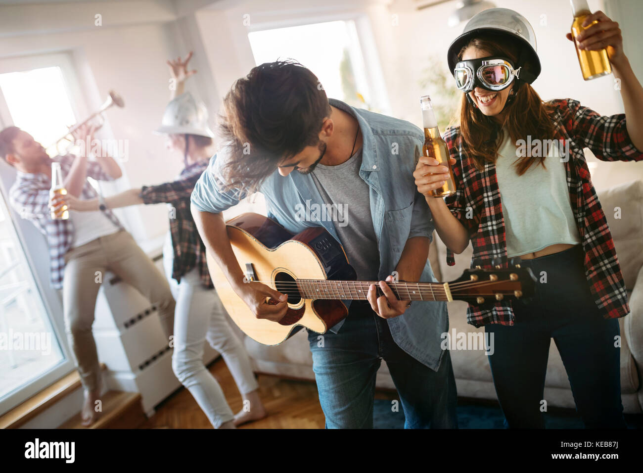 Cheerful friends having party together and playing instruments Stock ...