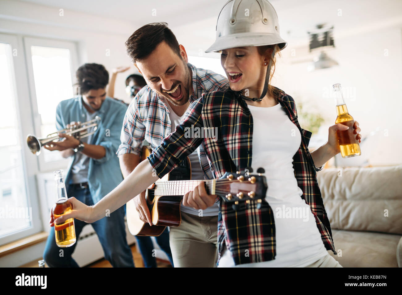 Cheerful friends having party together and playing instruments Stock ...