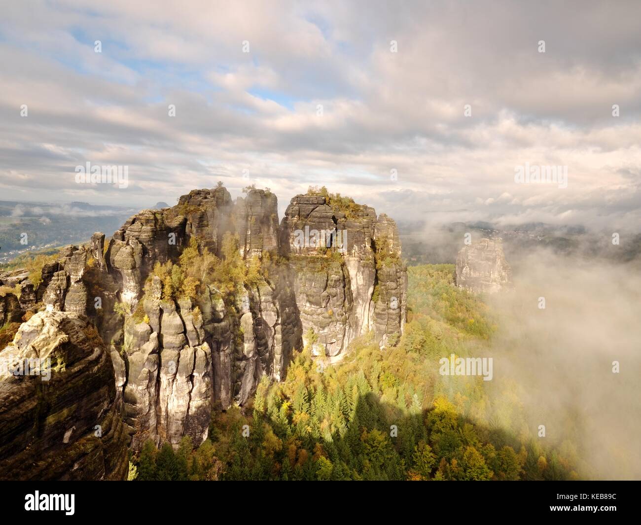Distant mountain range and heavy clouds of colorful mist above deep ...