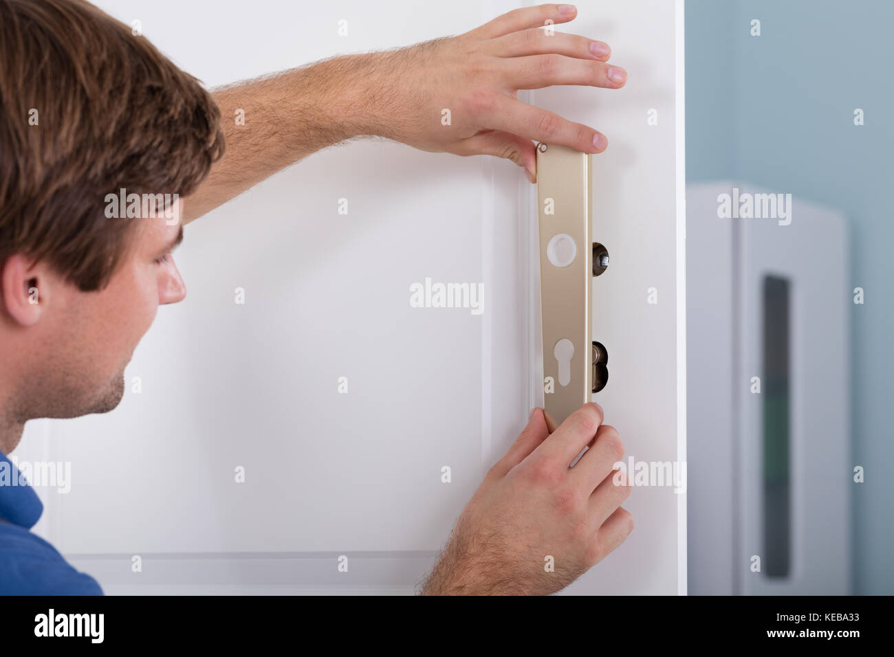 Young Carpenter Installing Door Lock At Home Stock Photo - Alamy