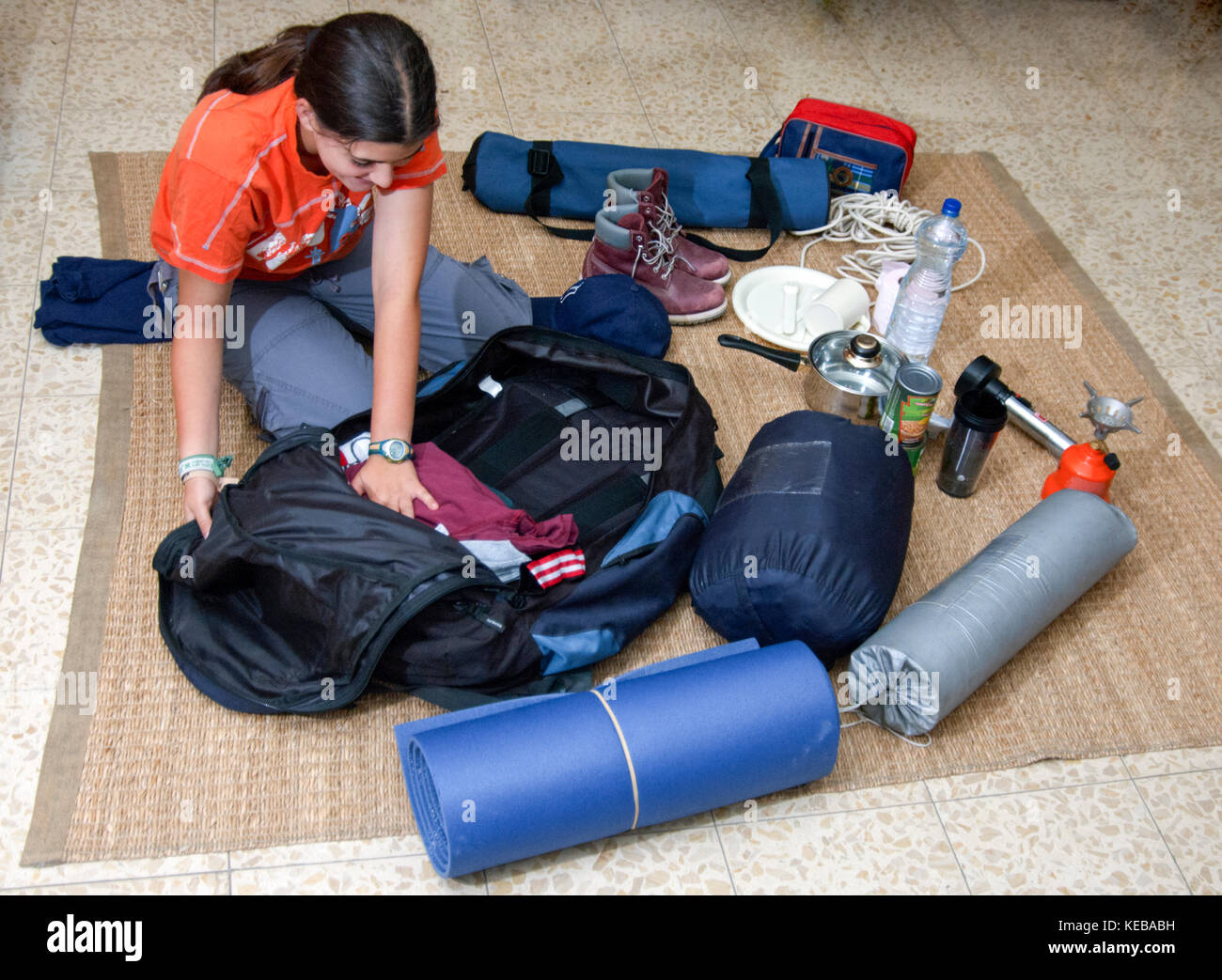 A young girl of 12 packing her backpack for a camping trip Stock Photo ...
