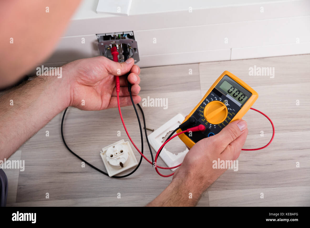 Close-up Of Person's Hand Holding Multimeter Checking Socket Voltage In ...