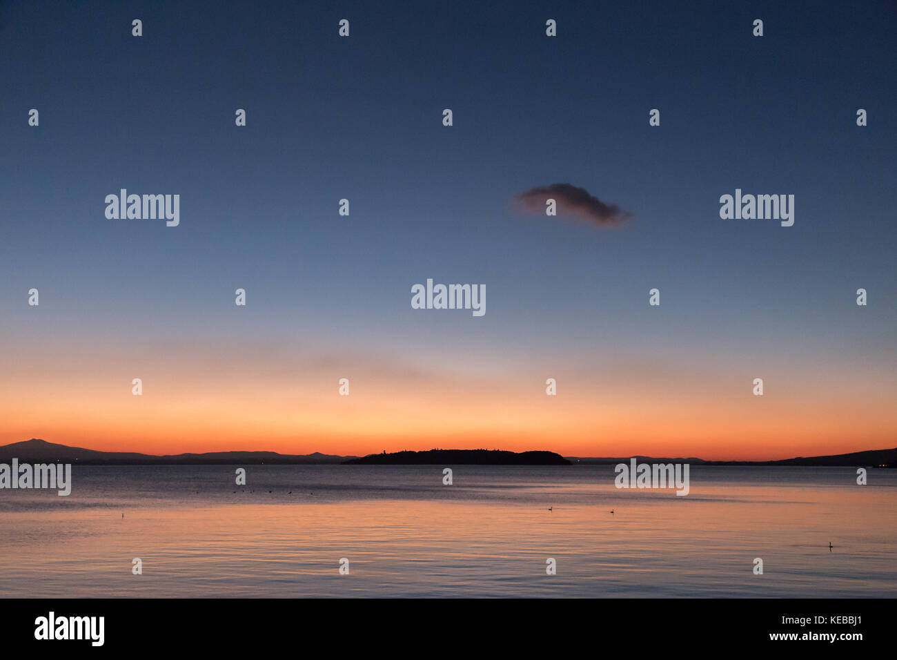 The end of sunset and the beginning of dusk on a lake, with big ...