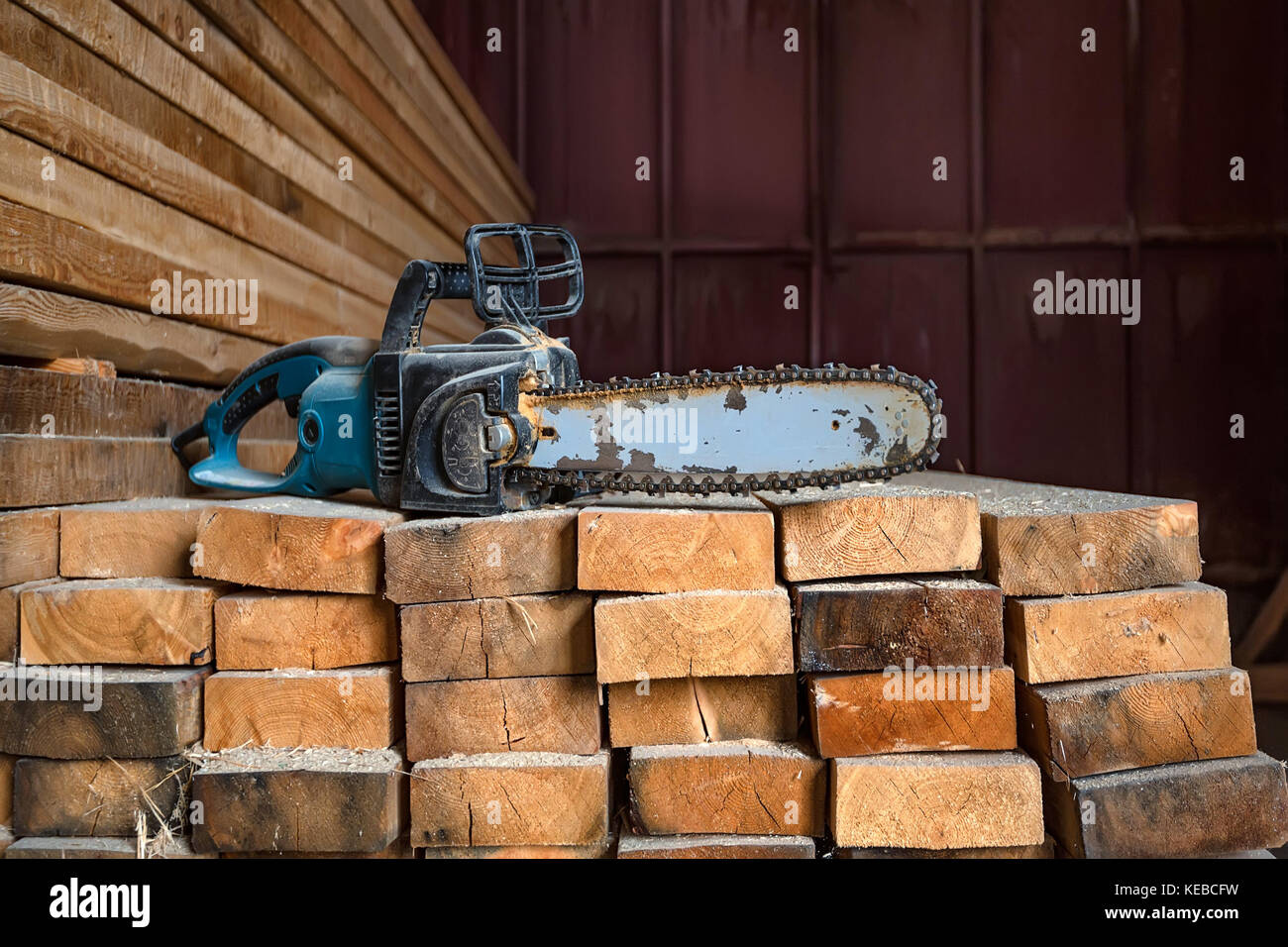Chainsaw on lumber background Stock Photo - Alamy