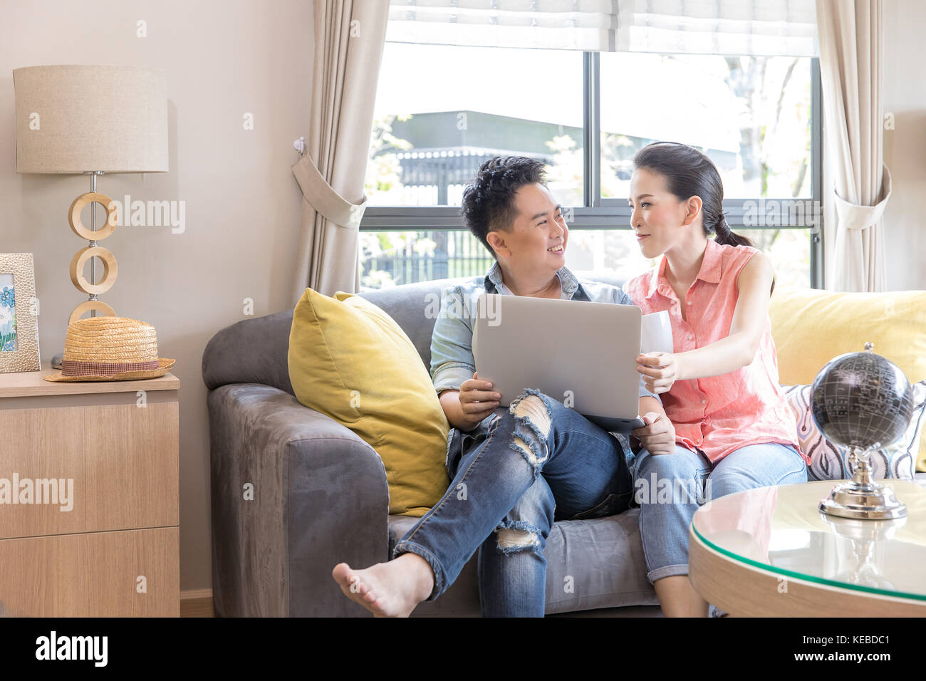 Young Couples using laptop tohether in living room of contemporary ...