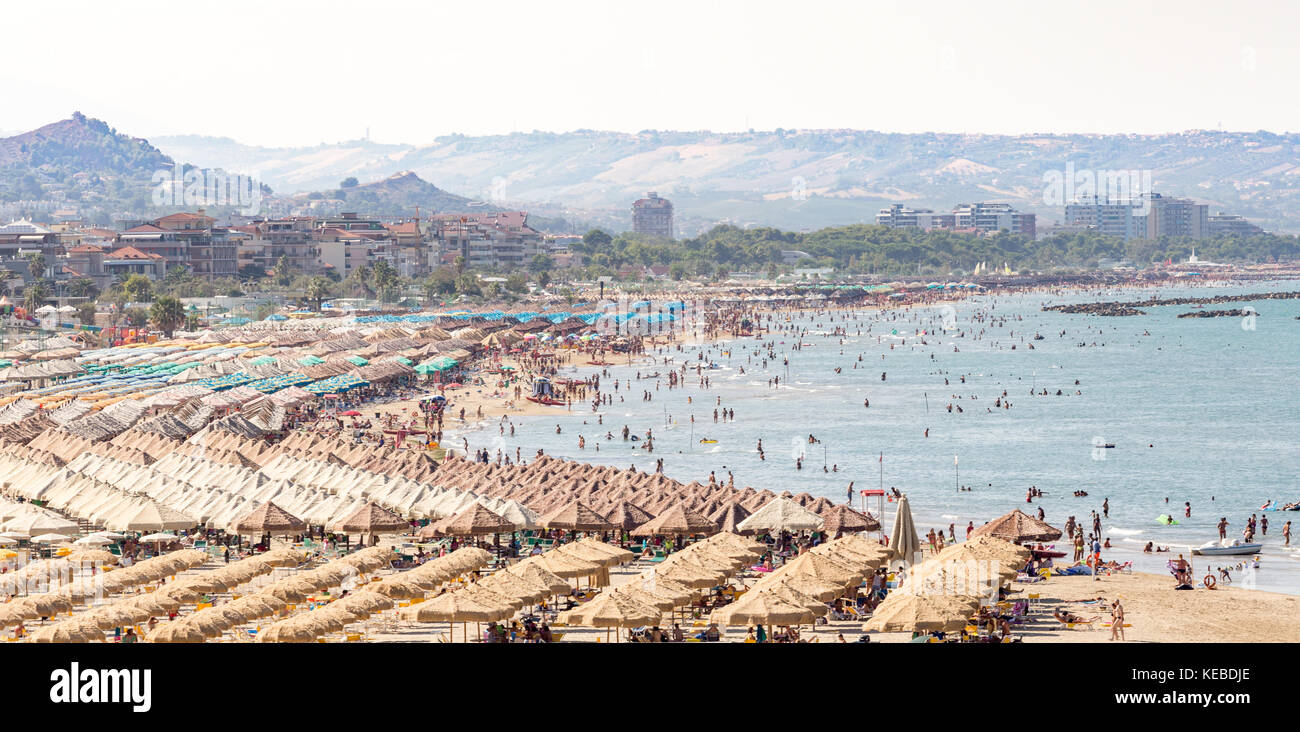 Sunny day atr beach of Pescara. Huge beach full of people and parasols ...