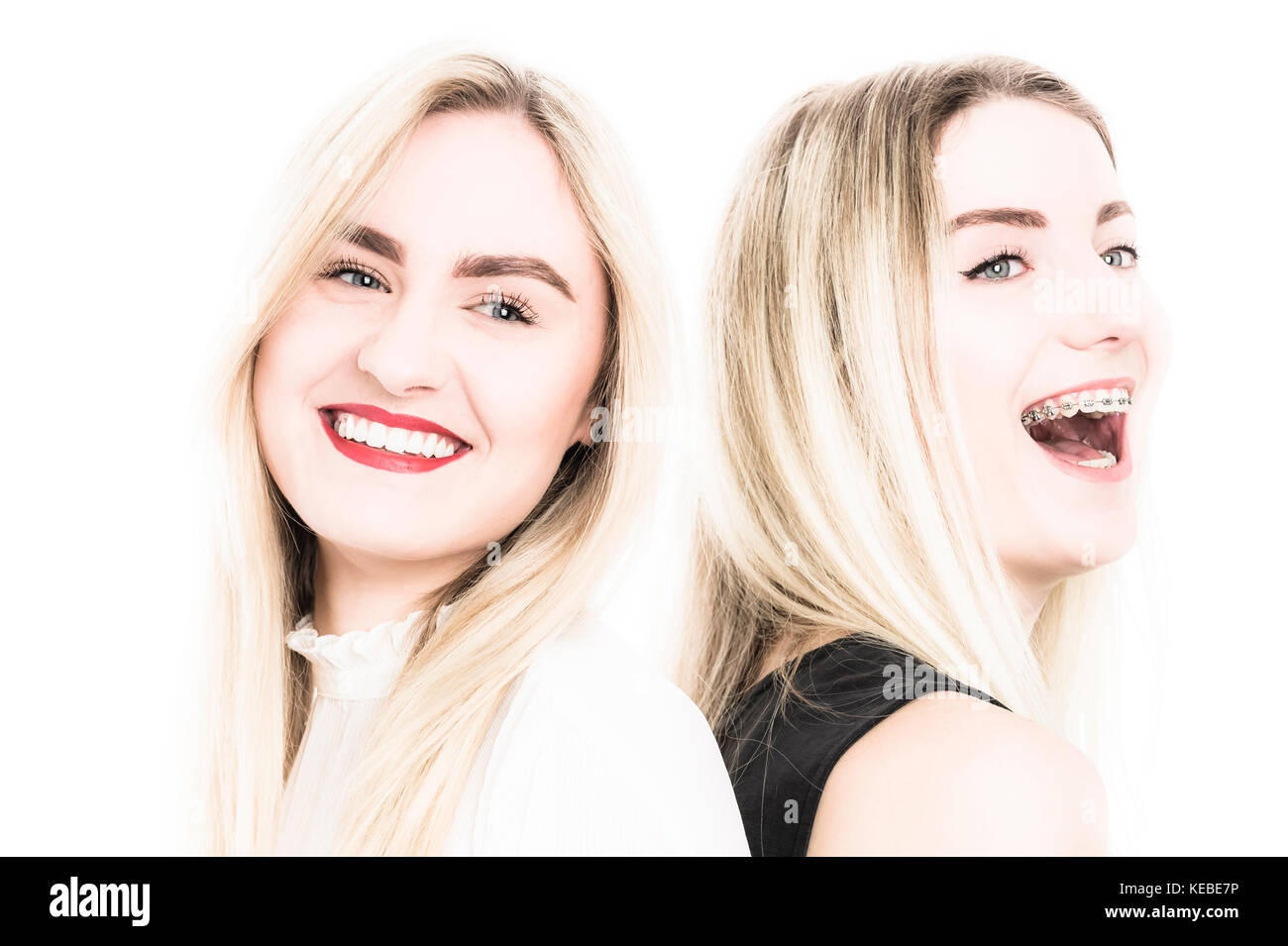 High key portrait of 2 sisters, back to back, smiling and laughing ...