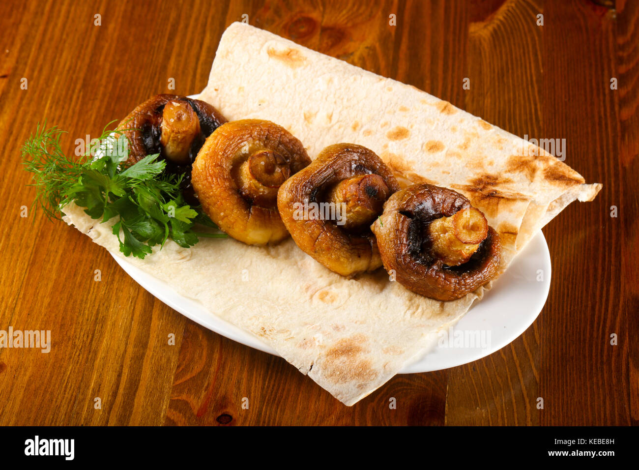 Grilled champignons with bread lavash Stock Photo - Alamy