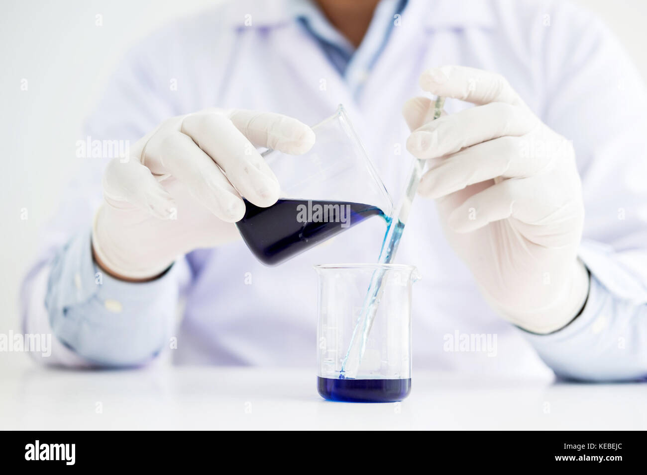 scientists and scientific equipment Pouring mixing reagents liqiud ...