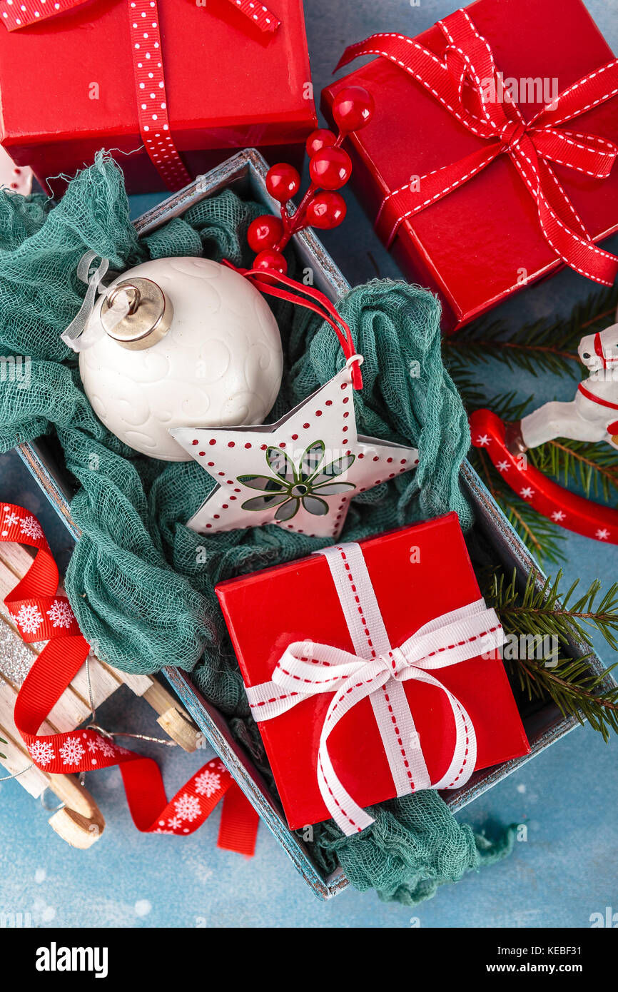 Christmas toys in wooden box and red gift boxes on blue background. Top ...