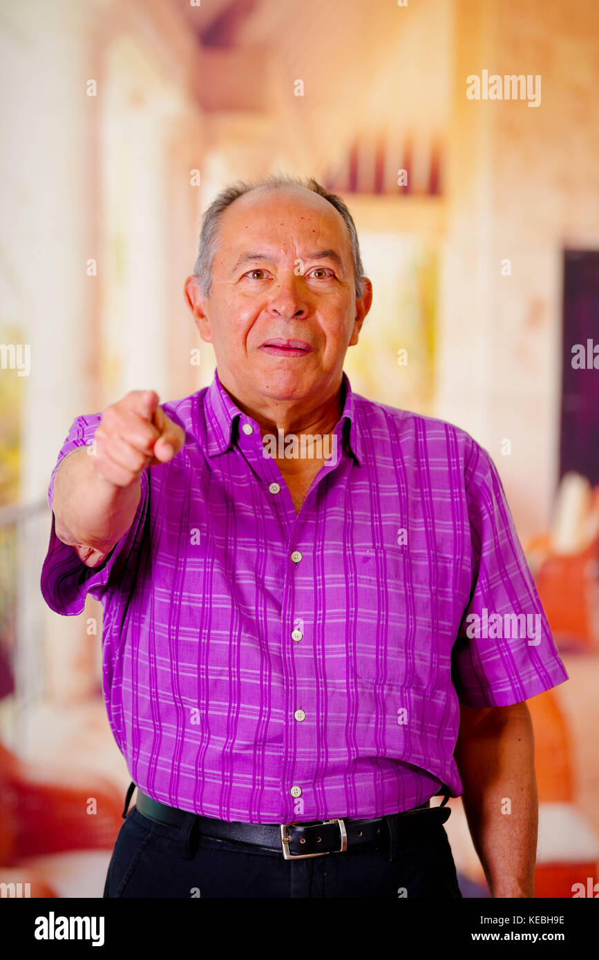 Close up of a happy old man, pointing with his hand in front and ...