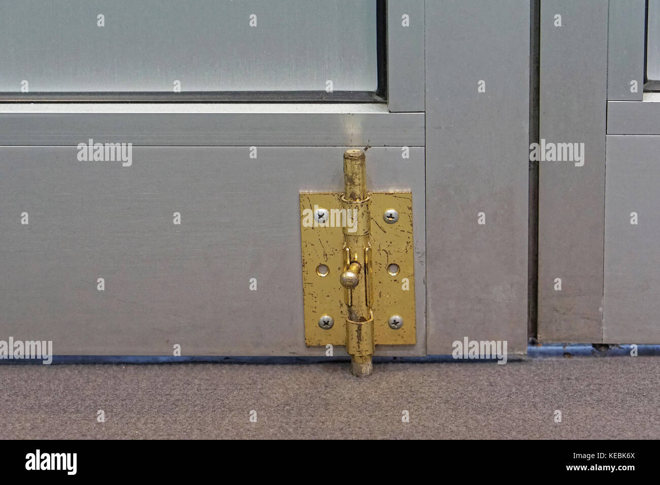 Latch lock at bottom of aluminum door Stock Photo - Alamy