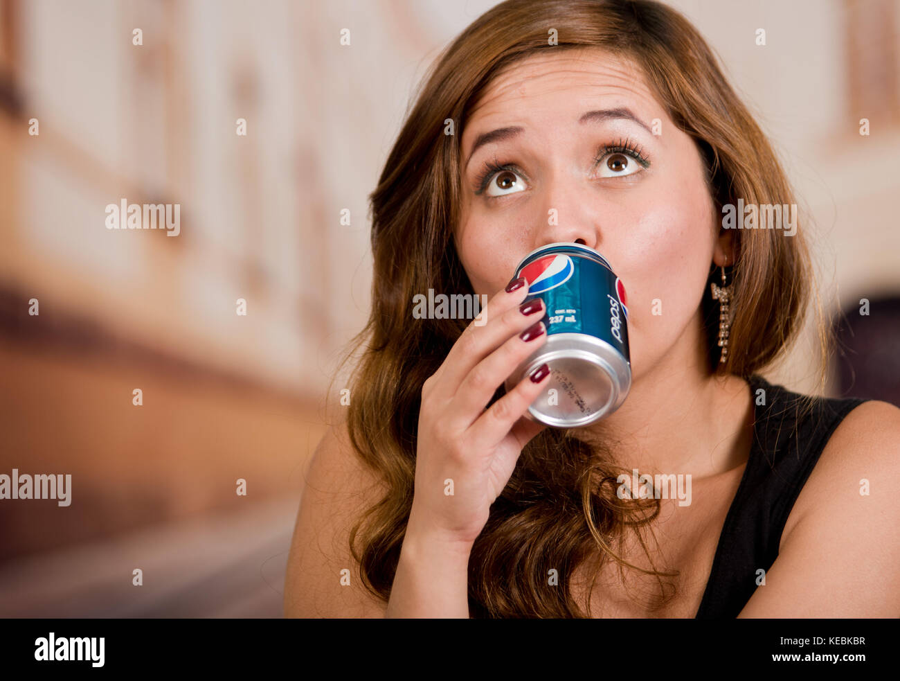 Pretty young woman drinking a pepsi in blurred city background Stock ...