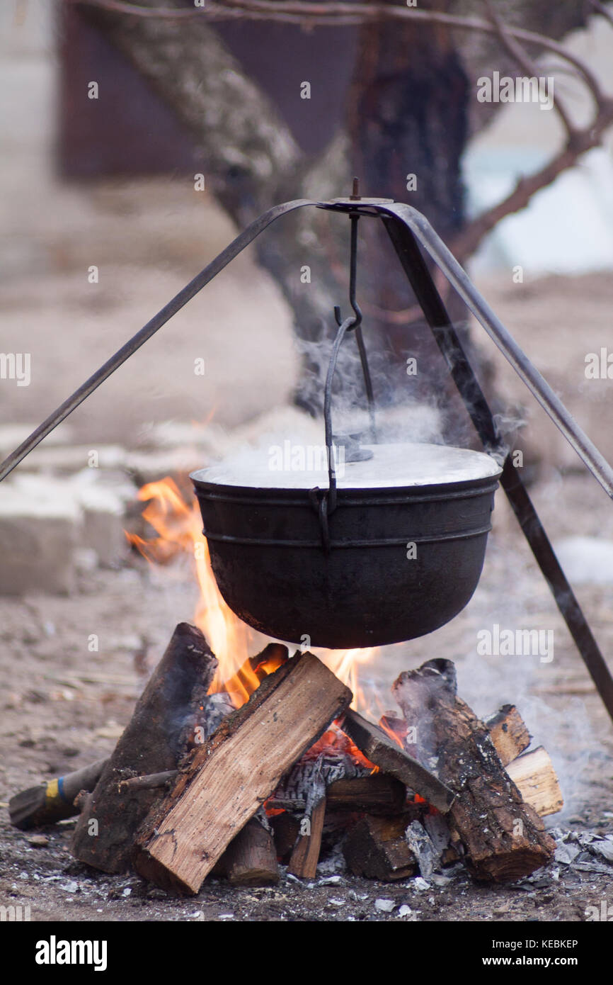 Cooking in the nature. Cauldron on fire in forest Stock Photo - Alamy