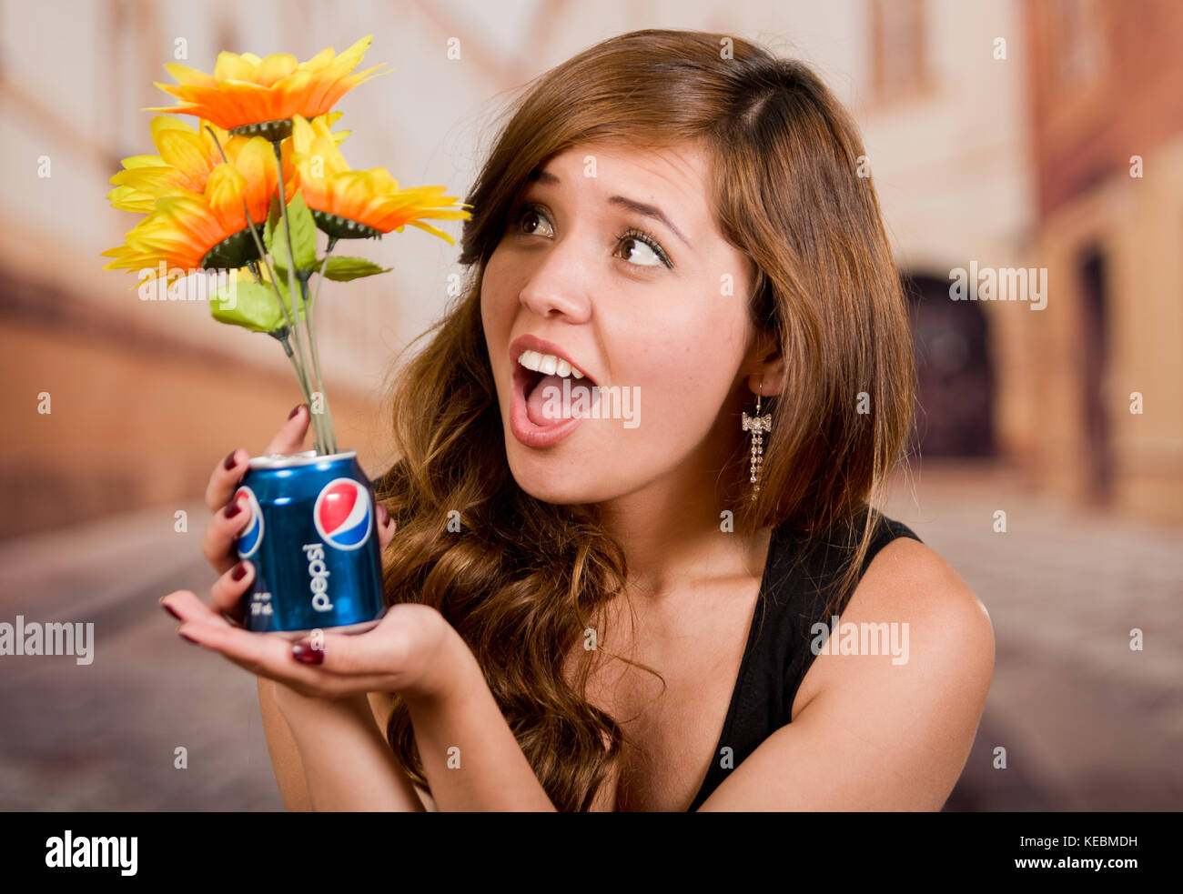 Pretty young woman holding a pepsi with sunflowers inside in blurred ...