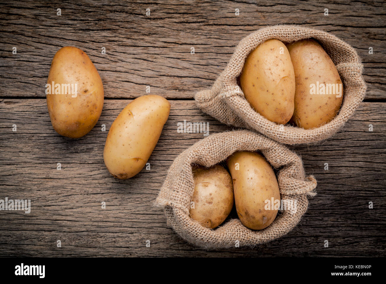 Fresh organic potatoes in hemp sake bag on rustic wooden background ...