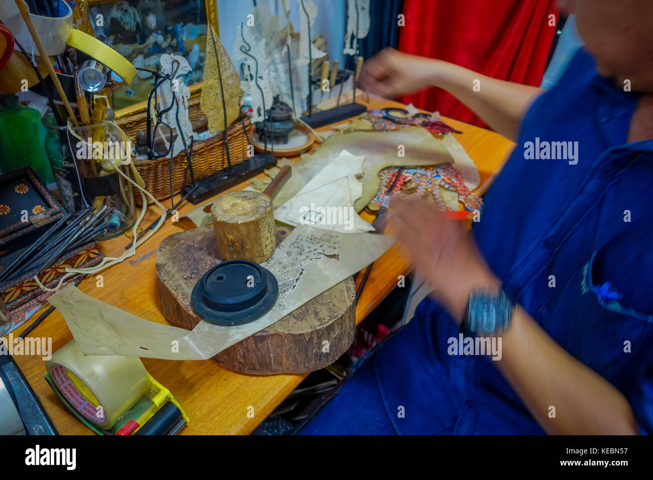 JAKARTA, INDONESIA: Local handcraft worker sitting by workplace desk ...