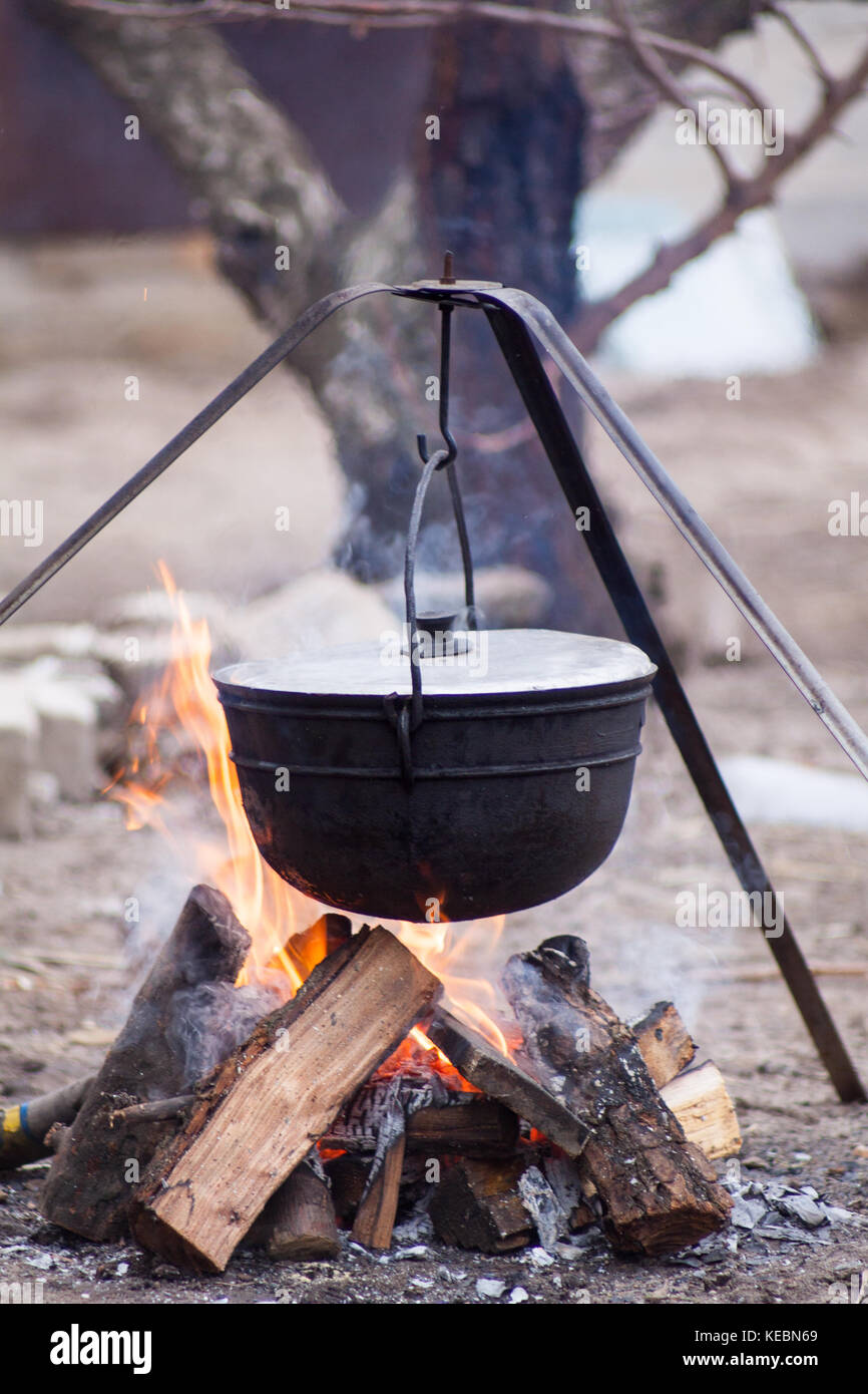 Cooking in the nature. Cauldron on fire in forest Stock Photo - Alamy